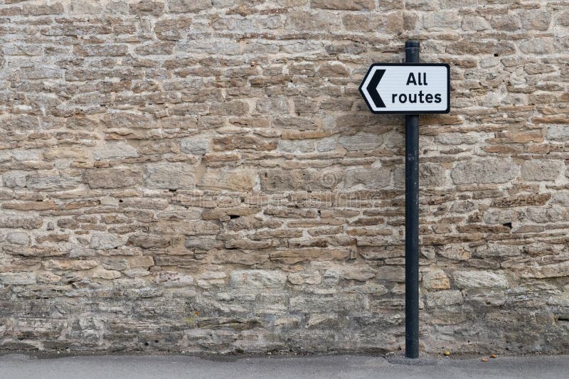 All Routes Road Sign Pointing Left in Front of an Old Stone Wall Stock ...