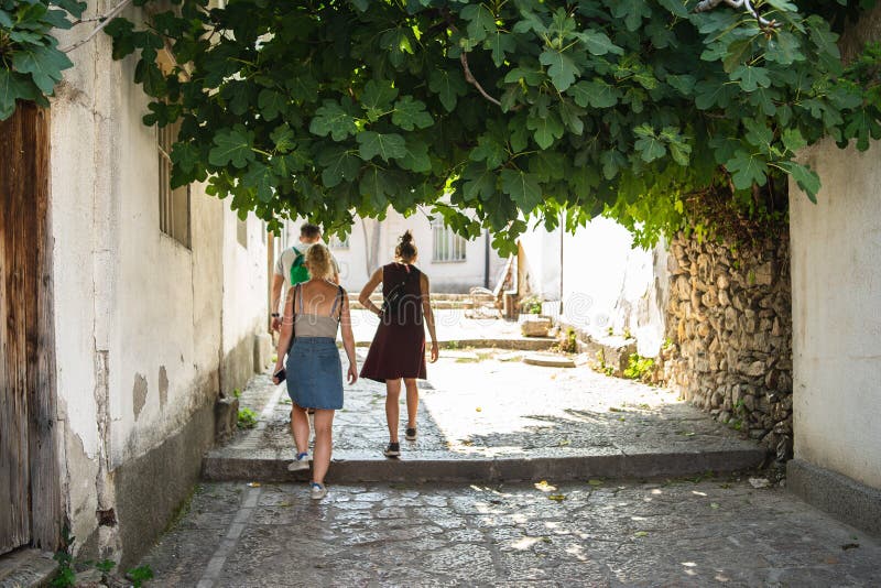 Alley with People Walking through it Surrounded by Old Buildings and ...