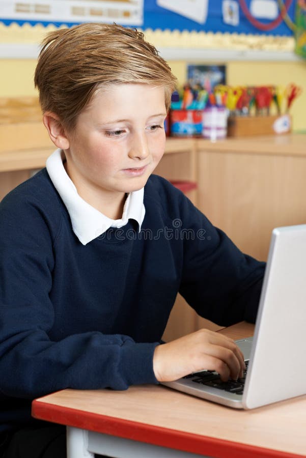 Allievo Maschio Della Scuola Elementare Che Utilizza Computer Portatile ... Allievo Maschio Della Scuola Elementare Che Utilizza Computer Portatile ...