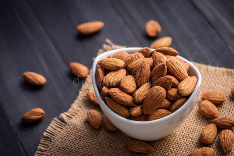 Almonds in Ceramic Bowl on Dark Wood Table. Almond Concept with ...