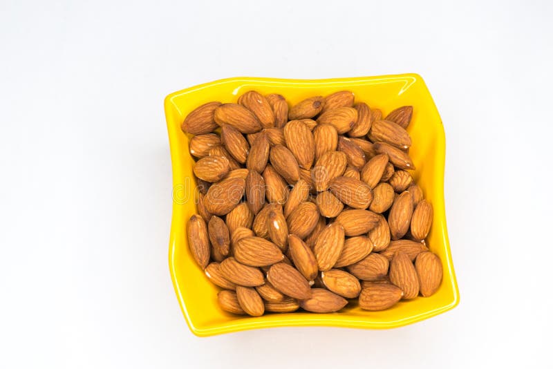 Almonds in yellow bowl stock photo. Image of ingredient - 144332880