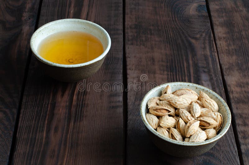 Almonds in Nutshell and Tea in Cup on Wooden Background Stock Image ...