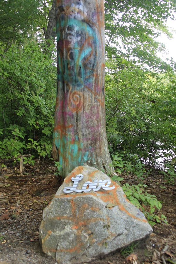Graffiti Tree with Rock and Sign Reading LOVE, Spread Love Not Hate ...