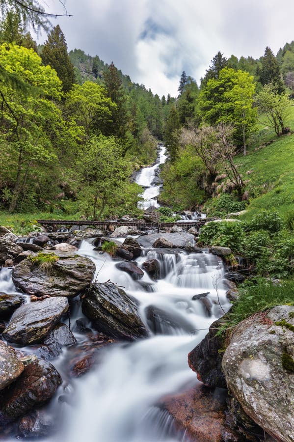 An Alpine Waterfall Surrounded by Greenery Stock Photo - Image of ...