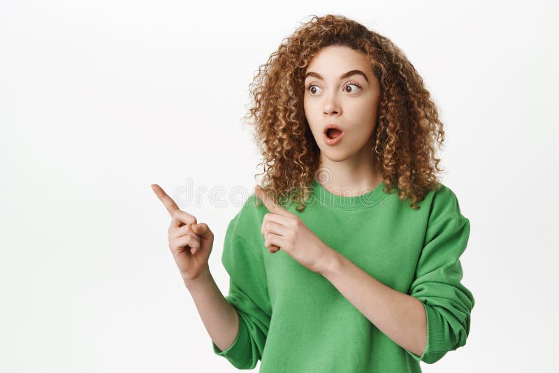 Amazed Curly Woman Say Wow Pointing And Looking Left At Advertisement