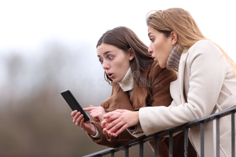 Amazed Friends Checking Smart Phone in Winter Stock Photo - Image of ...