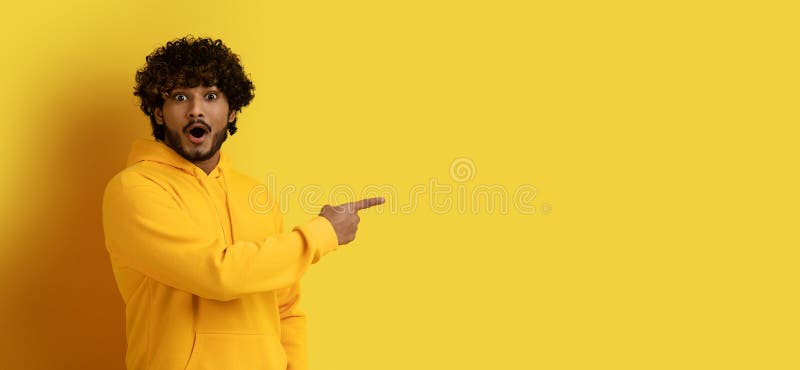 Amazed Indian Guy in Yellow Hoodie Pointing at Copy Space Stock Photo ... Amazed Indian Guy in Yellow Hoodie Pointing at Copy Space Stock Photo ...