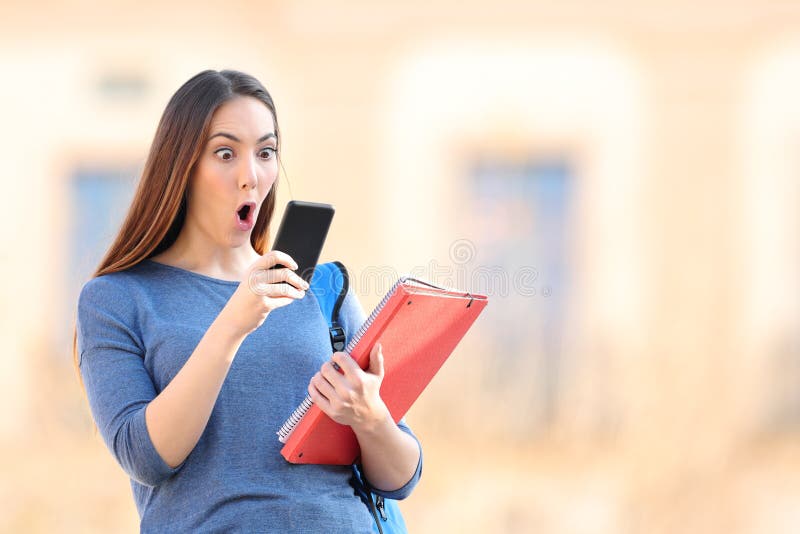 Amazed Student Checking Mobile Phone in a Campus Stock Photo - Image of ...