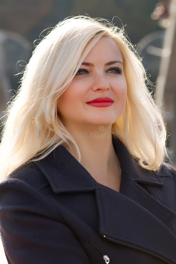 Amazing Blonde Woman With Bright Makeup Posing In Black Coat At Stock