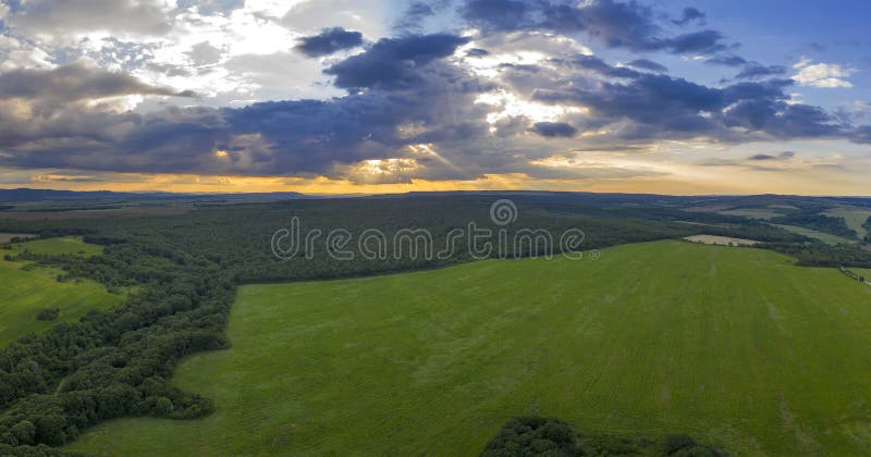 Panoramic View of Cloudy Sky with Sun Rays Over Green Field and Forest ...