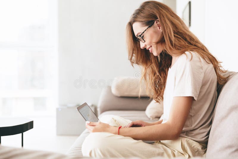 Amazing Pretty Lady Sitting on Sofa Using Tablet Computer. Stock Image ...