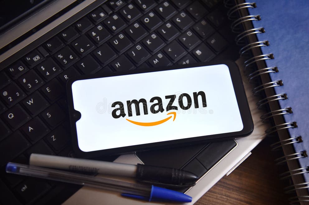 Amazon Logo Seen on a Mobile Phone Screen on a Table with Objects in ...