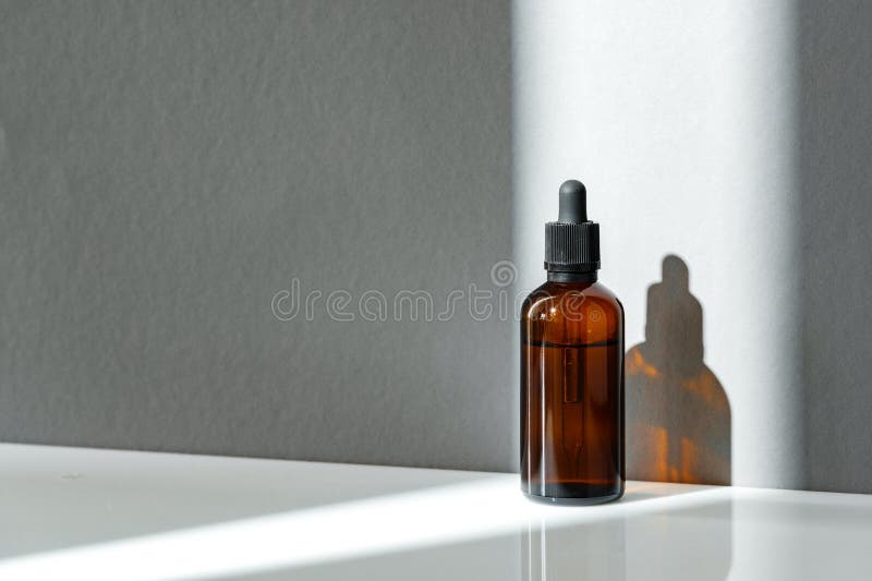 Amber Glass Dropper Bottle with Sunlight Shadow on White Surface Stock ...