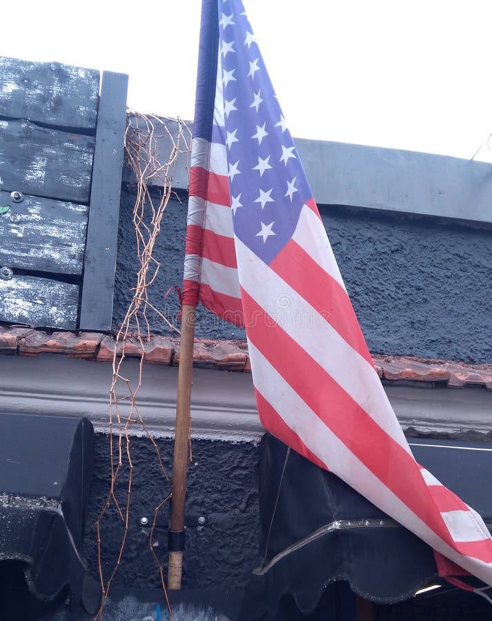 An American Flag Hanging on a Building Int the Street Stock Photo ...