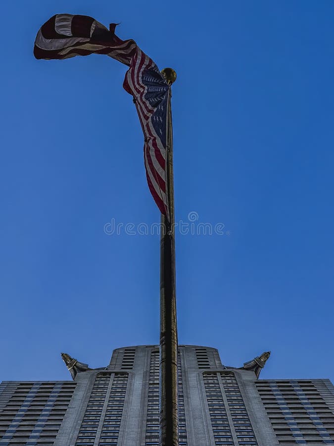 The American Flag on a Pole Floating on a Pole in the Air in an Urban ...