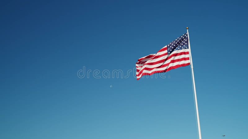 American Flag Waving in the Air Against a Blue Sky Stock Footage ...