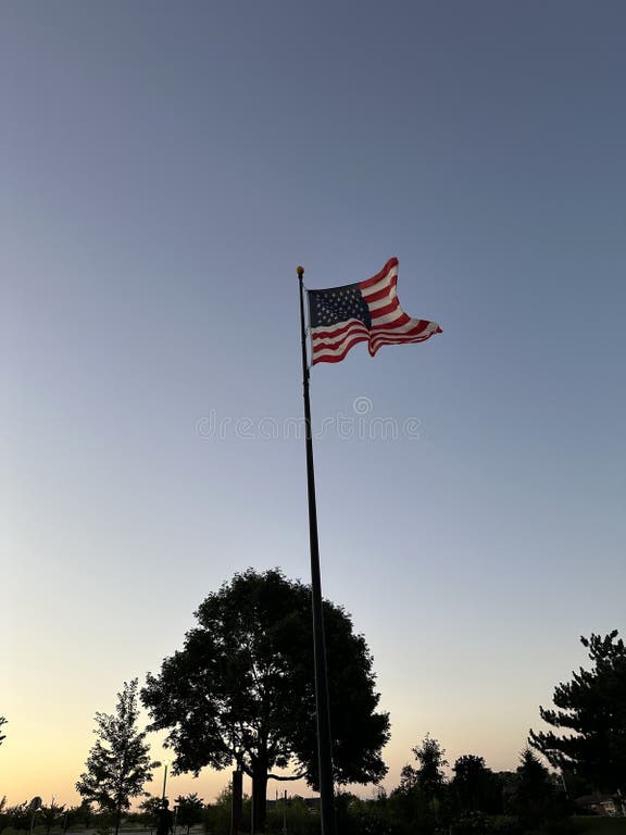 American Flag Waving in the Wind at Dusk Stock Image - Image of light ...