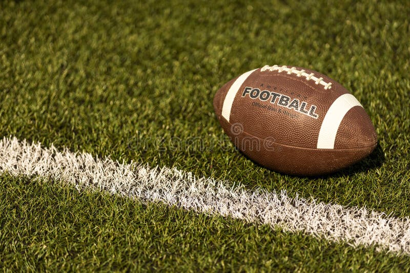 American Football Ball on the Grass of a Stadium Stock Image - Image of ...