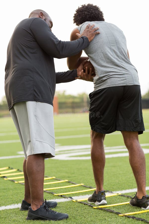 American Football Coach Training a Young Athlete. Stock Image - Image ...