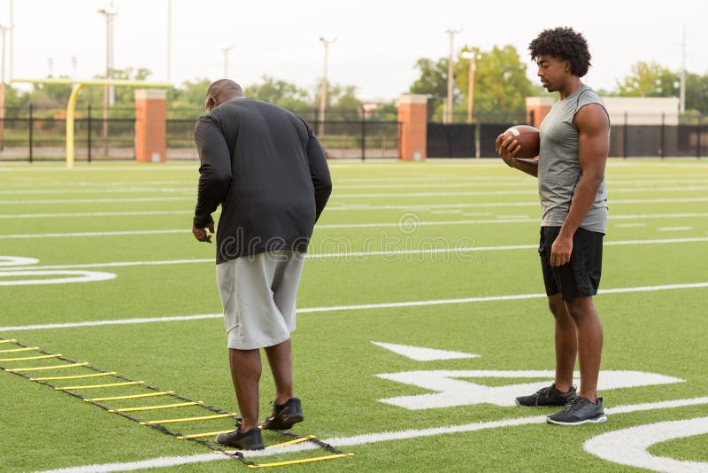 American Football Coach Training a Young Athlete. Stock Image - Image ...