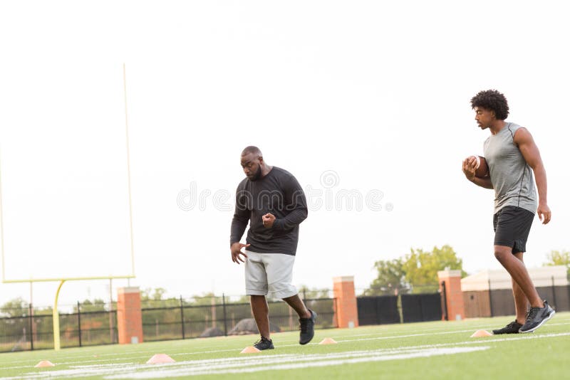 American Football Coach Training a Young Athlete. Stock Photo - Image ...