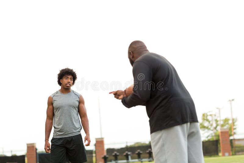 American Football Coach Training a Young Athlete. Stock Photo - Image ...