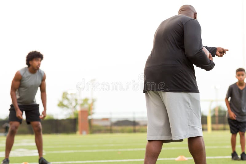 American Football Coach Training a Young Athlete. Stock Photo - Image ...