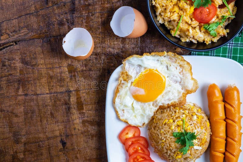 .American Fried Rice Served with Fried Eggs and Sausages on the Table ...