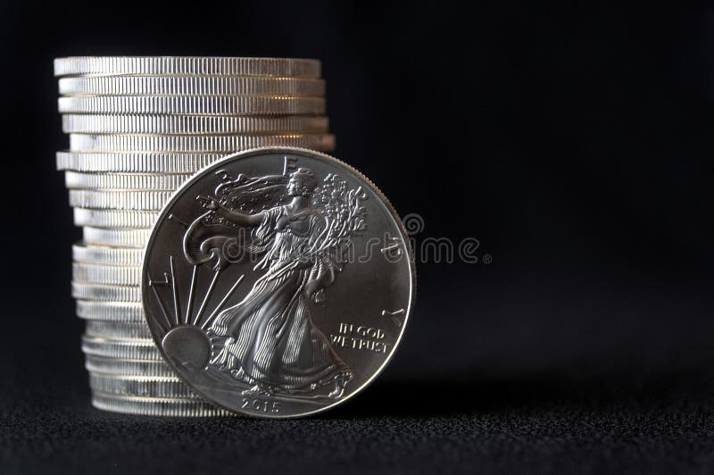 An American Silver Eagle Coin, Against a Stack of Silver Eagle Coins ...