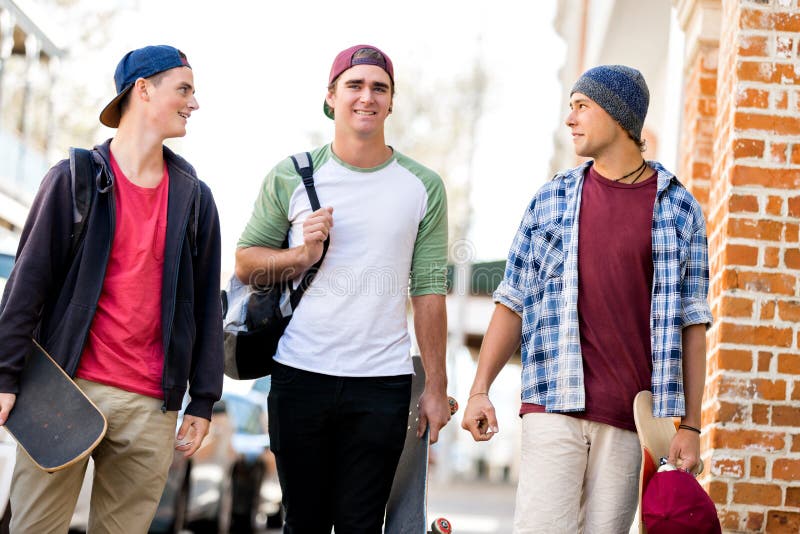 Amigos Adolescentes Que Andam Na Rua Com Skates Foto De Stock Imagem
