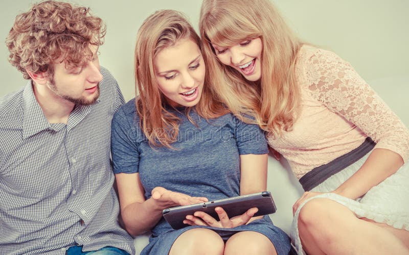 Amigos Que Relajan Internet De La Ojeada En La Tableta Imagen de ...