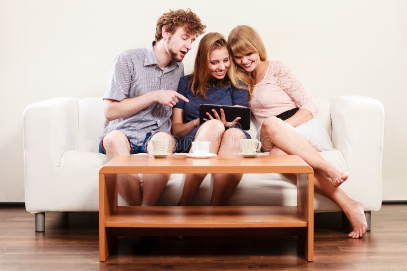 Amigos Que Relajan Internet De La Ojeada En La Tableta Imagen de ...