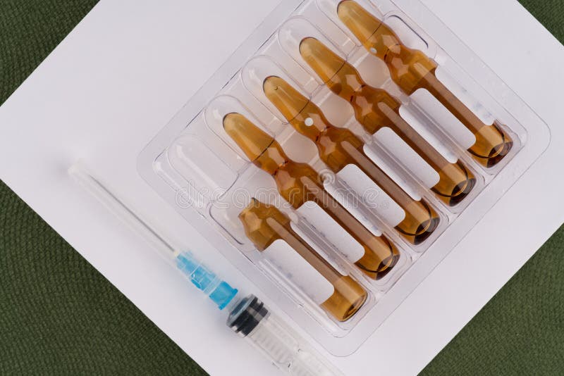 Ampoules with Medication for Injections and a Syringe Nearby. Top View ...