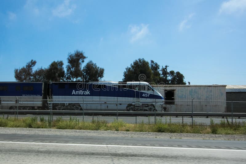 Amtrak Train Rolling Down the Rails beside Freeway Editorial Image ...