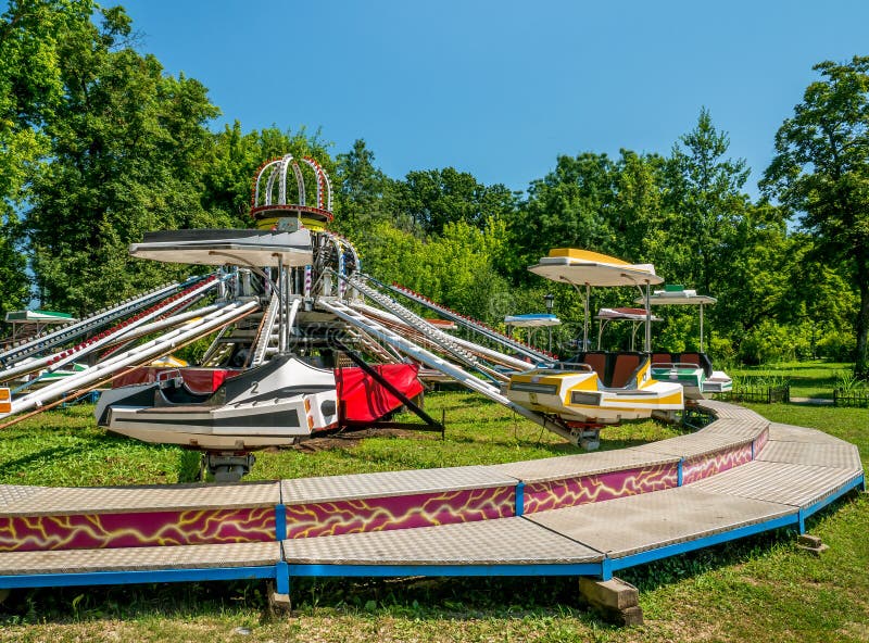 Amusement Park Ride Machine and Green Trees Against Blue Sky Stock ...