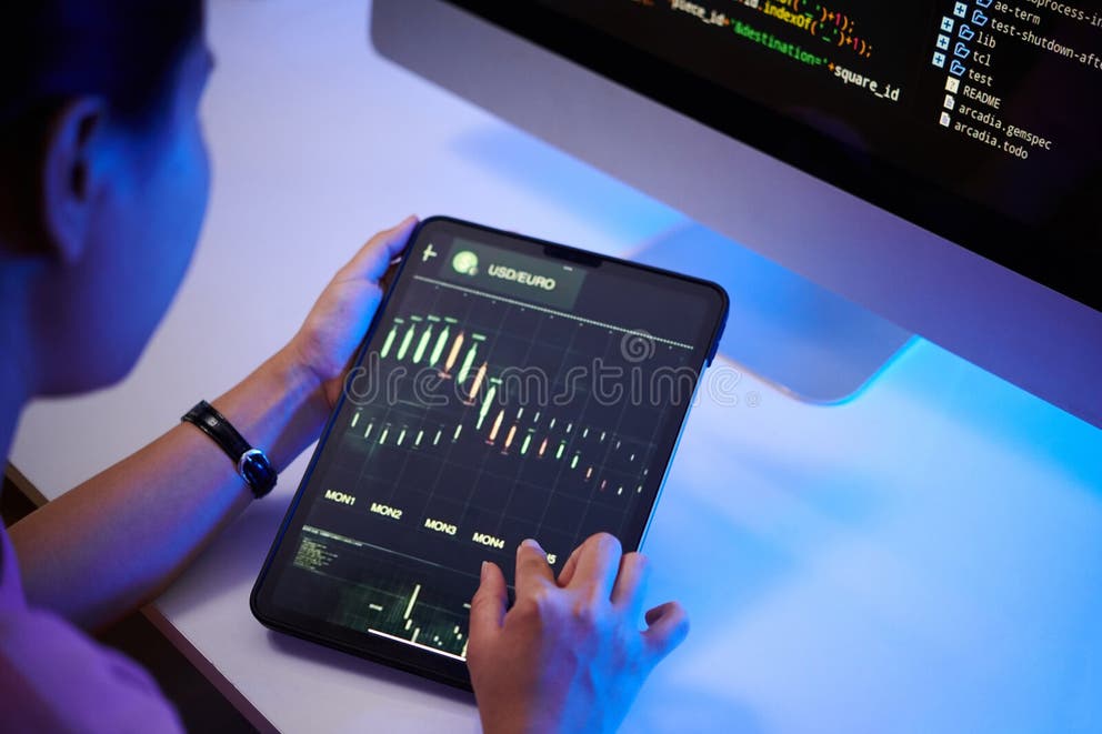 Analyzing Data on Tablet with Code on Monitor in Background Stock Image ...