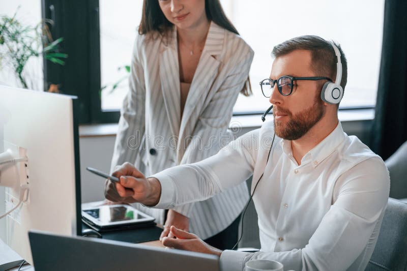 Analyzing Information that is on the Screen. Two Employees are Working ...