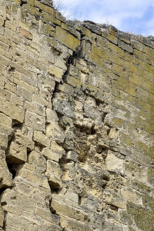 An Ancient Moss-covered Stone Wall with Deep Cracks and Collapsed ...