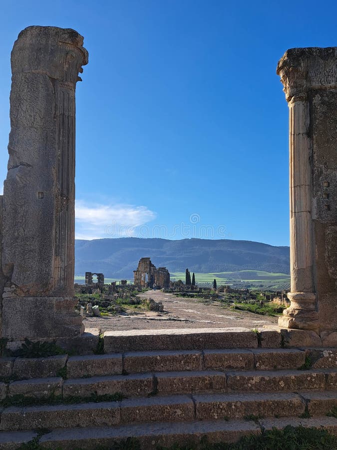Ancient Ruins Framed by Majestic Mountains Under a Clear Blue Sky ...