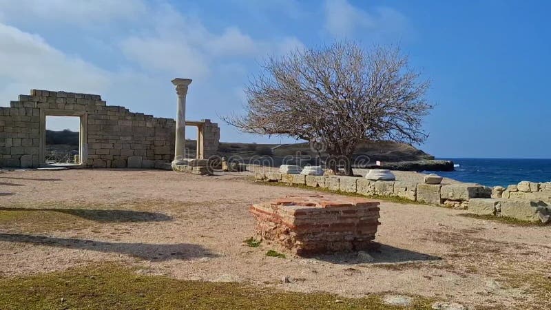 Ancient Ruins with Stone Columns and an Open Archway Under a Cloudy Sky ...