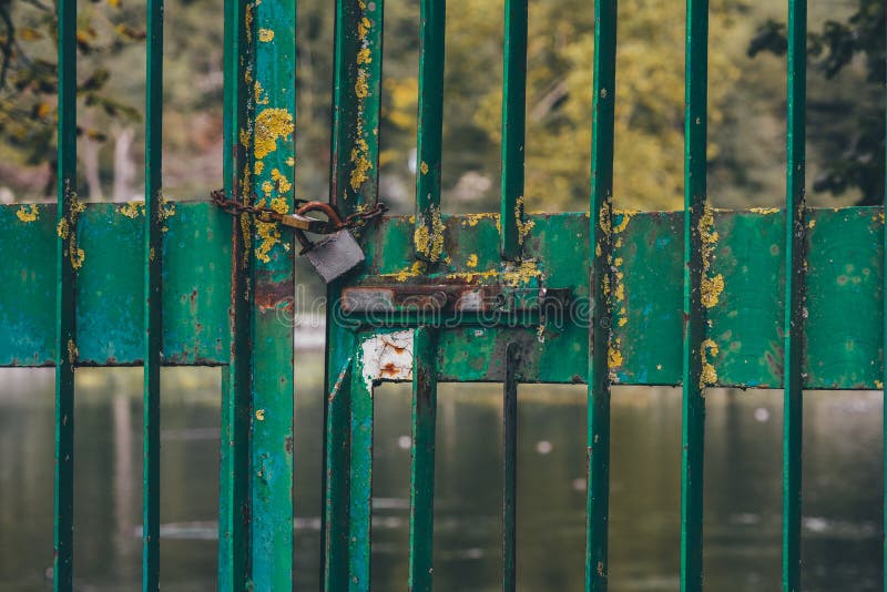 Ancient Rusty Iron Gate with Padlock, Small Lake in the Background ...