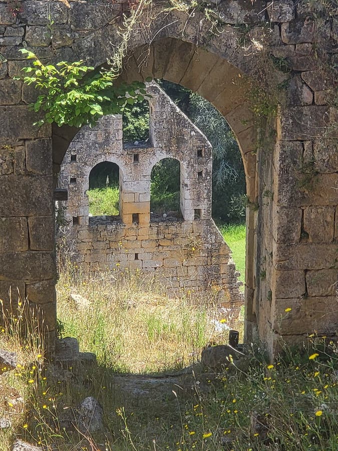 Ancient Stone Archway Overlooking Medieval Ruins in a Serene Meadow ...