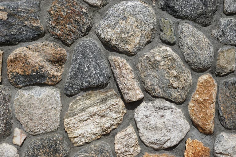 Solid Rock Wall with Irregular Stones Set in Gray Mortar Stock Photo ...