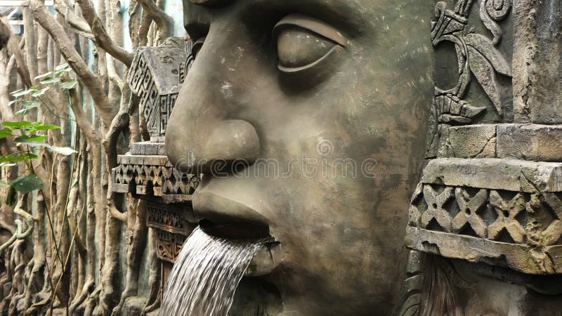 An Ancient Stone Statue of the Face of a Deity in the Jungle with a ...