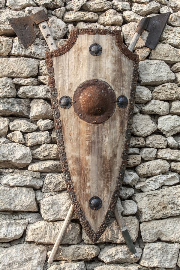 Ancient Weapons on a Stone Wall. Wooden Shield with Iron Accents Stock ...