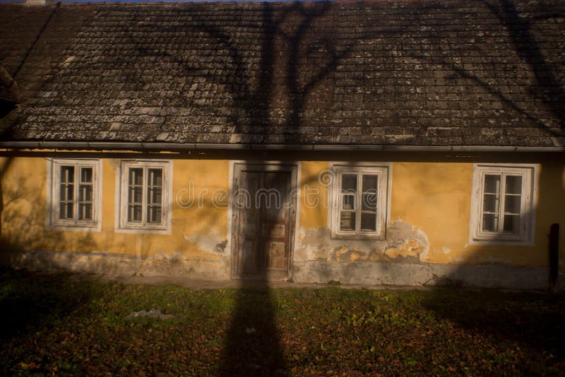 Ancient Yellow House with Wooden Window Frames and Bare Tree Shadows ...