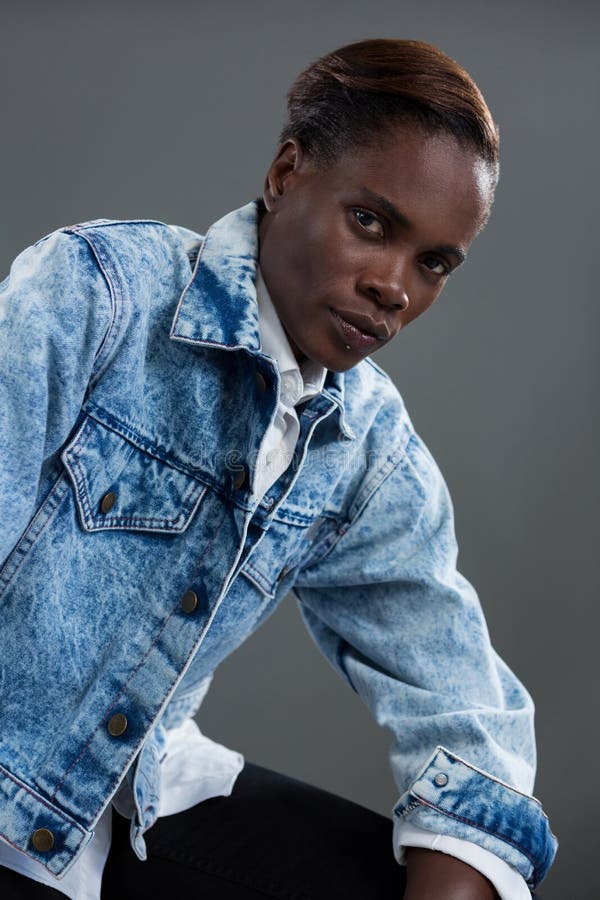 Androgynous Man in Denim Jacket Posing Against Grey Background Stock ...