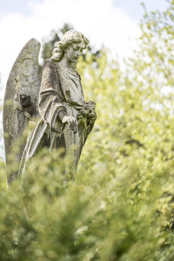 Angel Sculpture between Blurred Spring Foliage Stock Photo - Image of ...