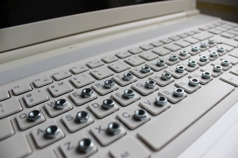 Angled Side View of a Computer Keyboard with an Iron Nut on Each Button ...
