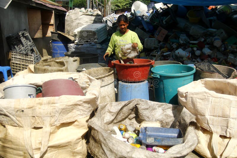 Workers of a Materials Recovery Facility Sort through Plastic Waste and ...